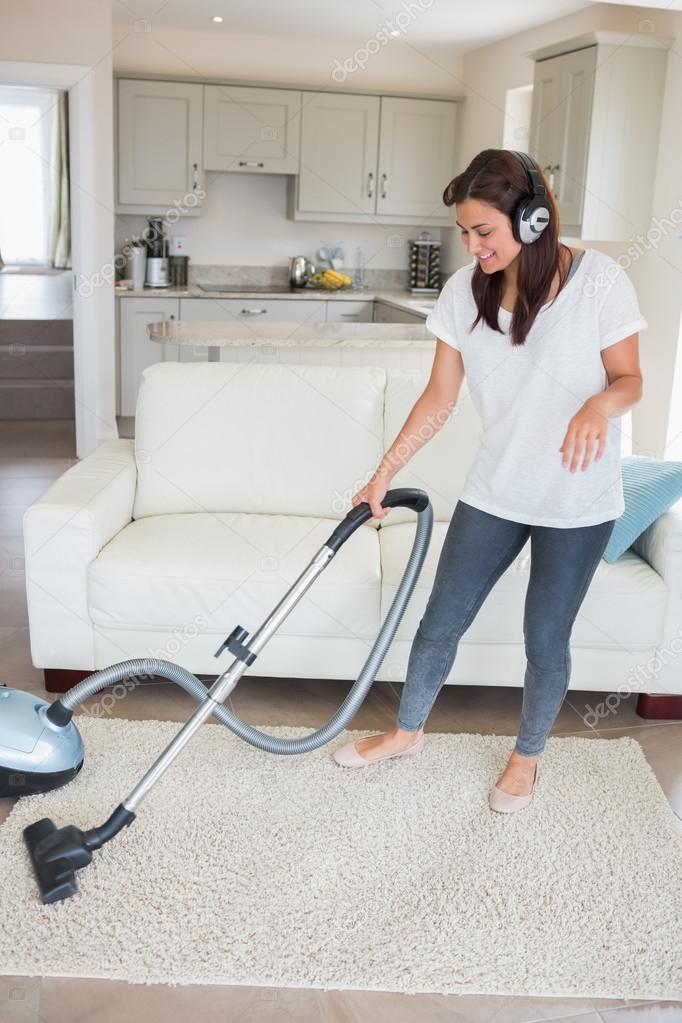 Woman wearing headphones while hoovering — Stock Photo © Wavebreakmedia ...