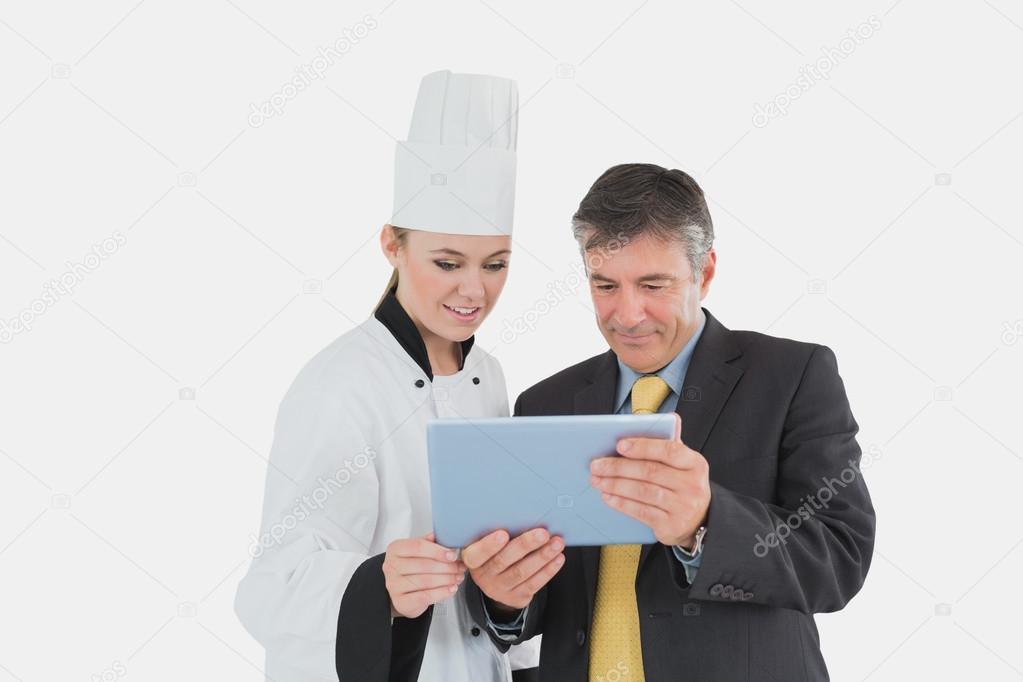 Businessman and female chef using digital tablet Stock Photo by ...