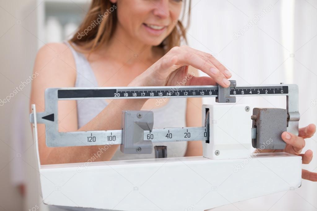 Woman adjusting scale Stock Photo by ©Wavebreakmedia 24115775