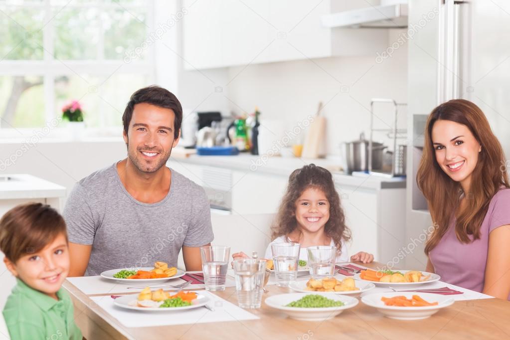 Familia sonriente cenando 2024