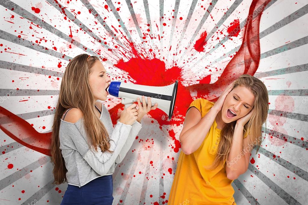 Girl shouting at another through a megaphone as she is covering her ...