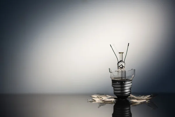 Shattered light bulb standing with copy space - Stock Image - Everypixel