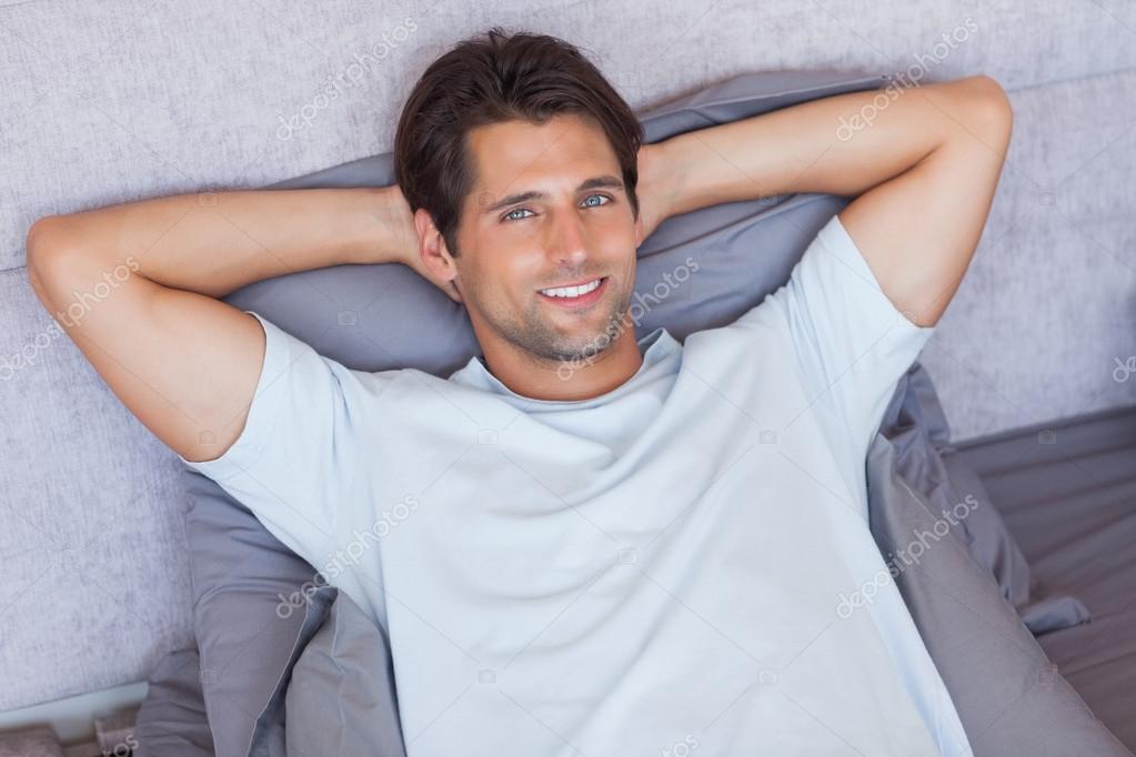 Handsome man lying down in his bed — Stock Photo © Wavebreakmedia #28055631