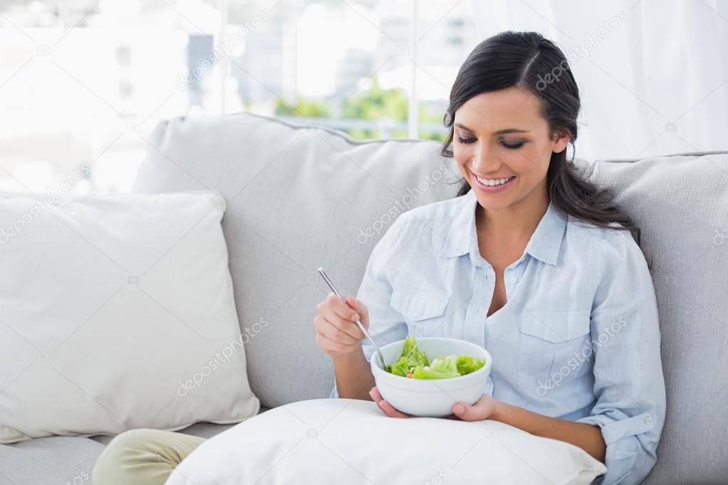 Woman relaxing on the sofa eating salad Stock Photo by ©Wavebreakmedia ...