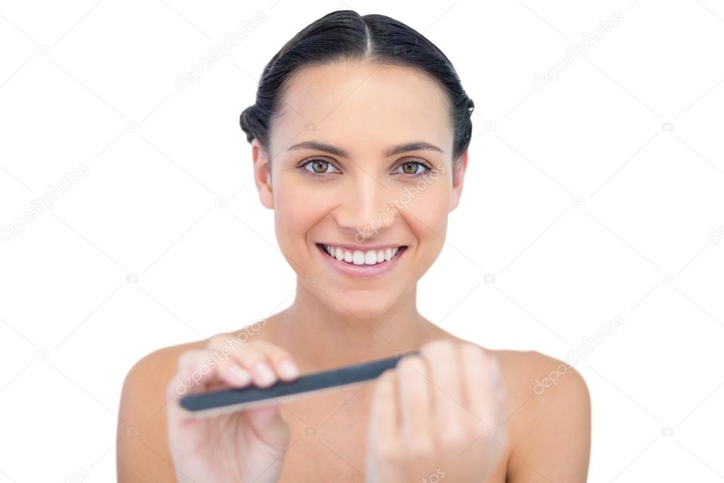 Smiling natural young model using nail file Stock Photo by ...