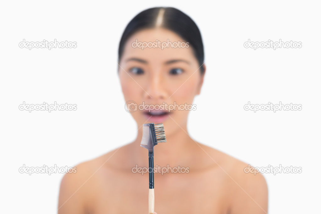 Curious natural model holding eyebrow brush Stock Photo by ...