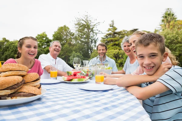 Extended family having dinner outdoors at picnic table - Stock Image ...