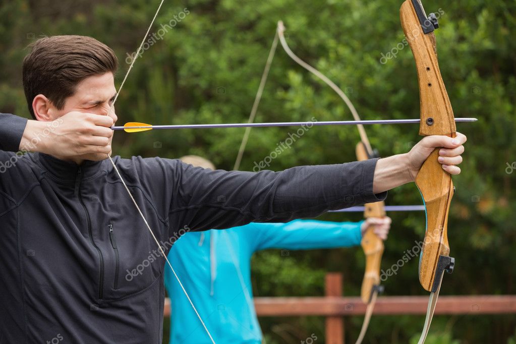 Handsome man practicing archery — Stock Photo © Wavebreakmedia #31465023