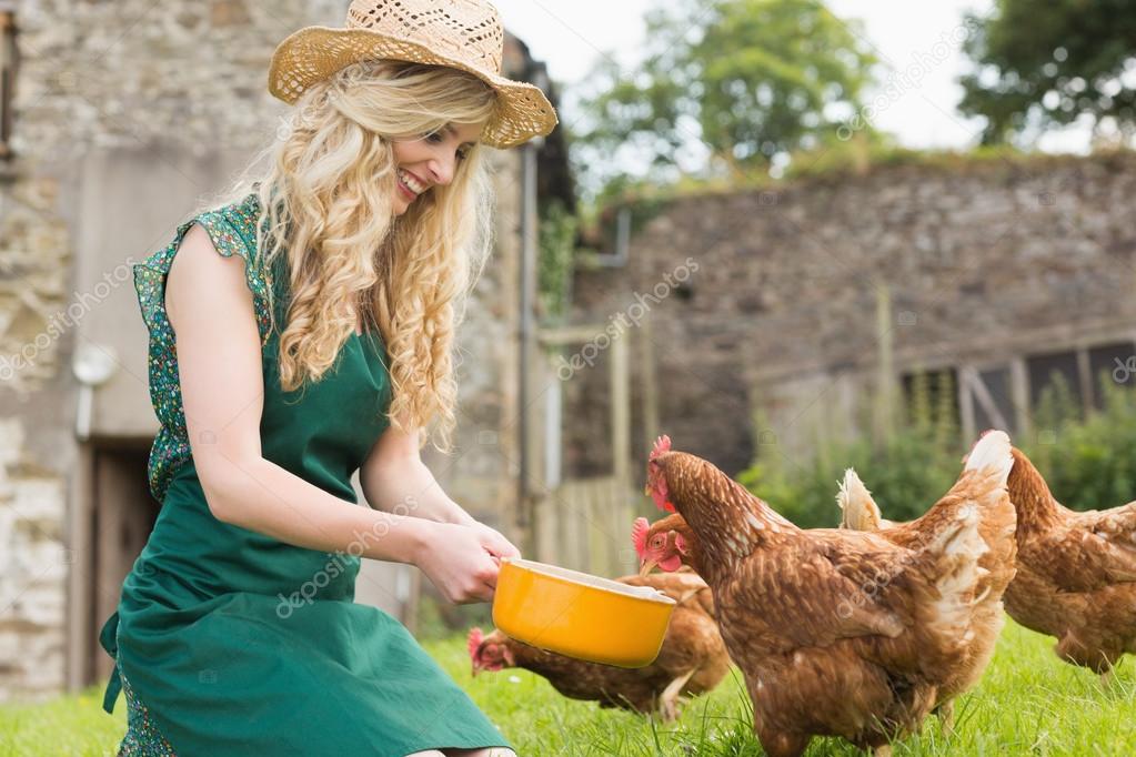 Young woman feeding her chickens Stock Photo by ©Wavebreakmedia 33436233