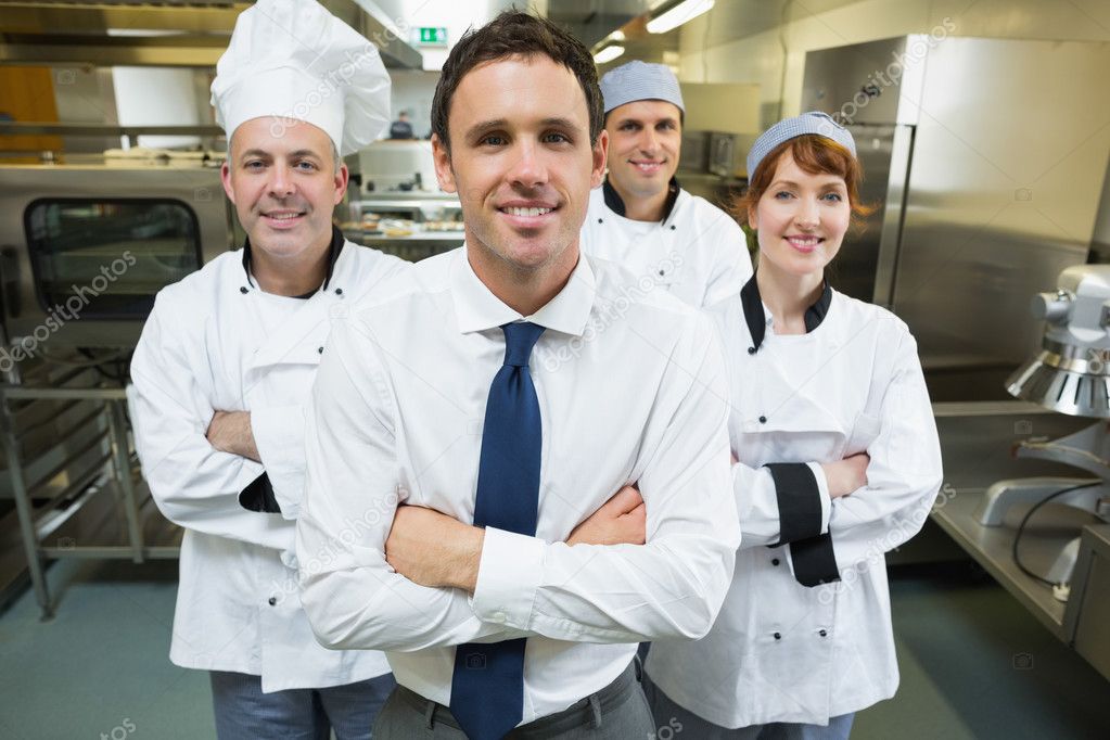 Restaurant manager posing in front of team of chefs Stock Photo by ...