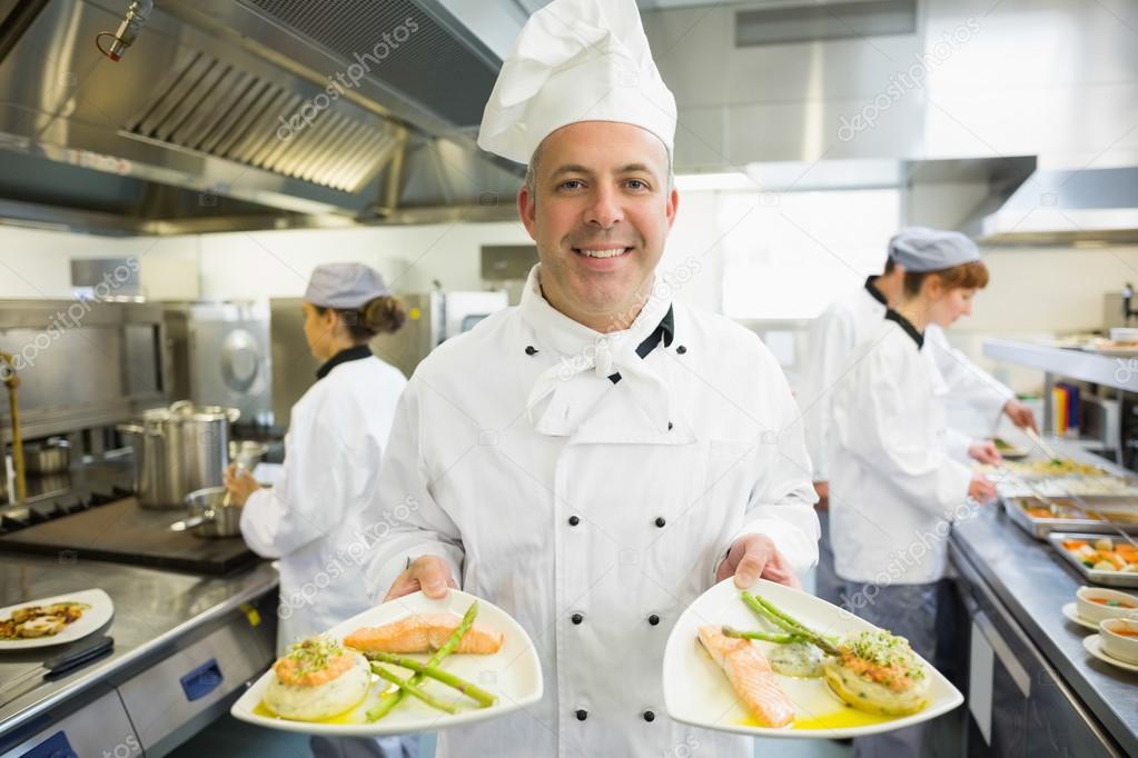 Mature head chef presenting proudly some dinner plates Stock Photo by ...