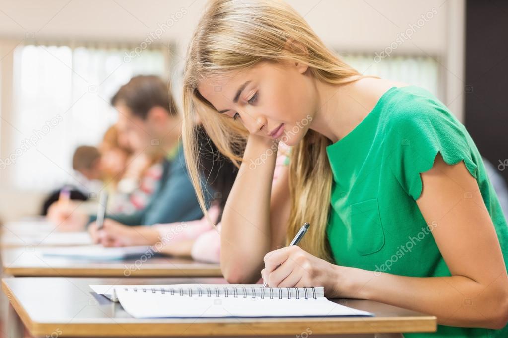 Students writing notes in classroom — Stock Photo © Wavebreakmedia ...