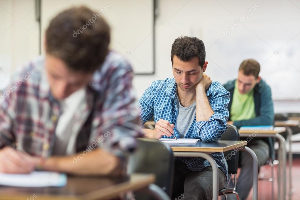 Students writing notes in classroom — Stock Photo © Wavebreakmedia ...