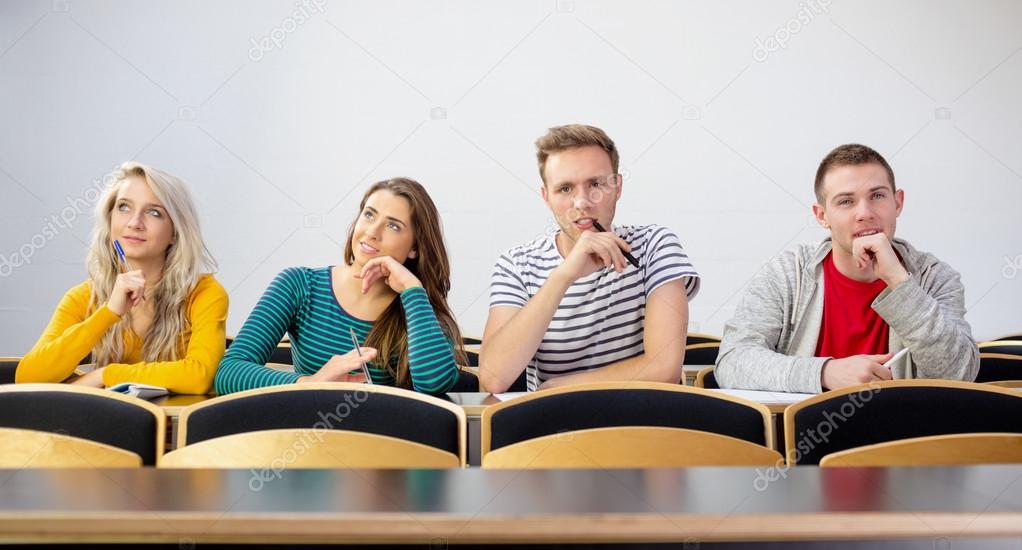 Estudiantes universitarios sonrientes reflexivos en el aula 2023