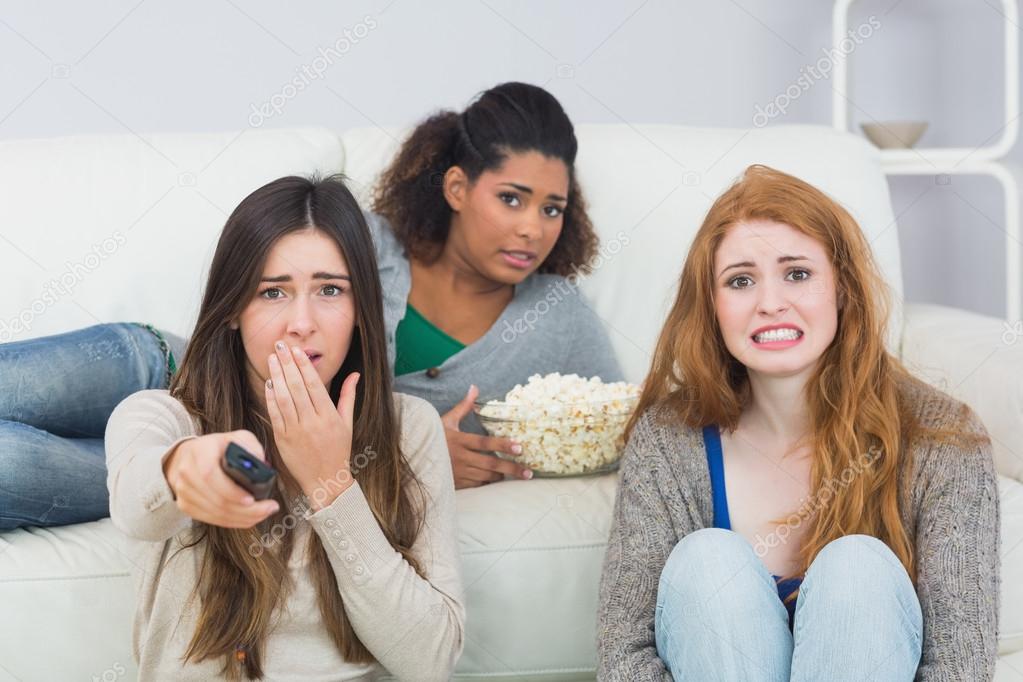 Scared friends with remote control and popcorn bowl at home — Stock ...