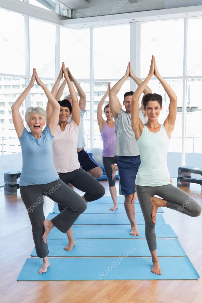 Class standing in tree pose at yoga class — Stock Photo ...