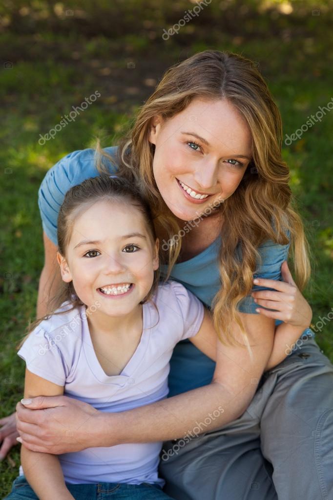 Smiling mother embracing her daughter at park — Stock Photo ... Smiling mother embracing her daughter at park — Stock Photo ...