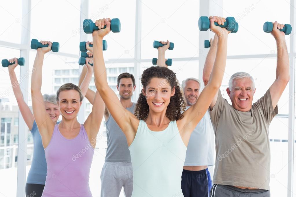 Class exercising with dumbbells in gym — Stock Photo © Wavebreakmedia ...