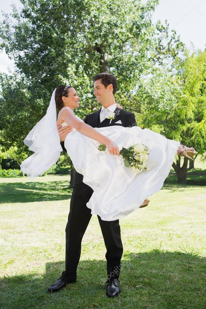 Groom carrying bride in arms — Stock Photo © Wavebreakmedia #42938083
