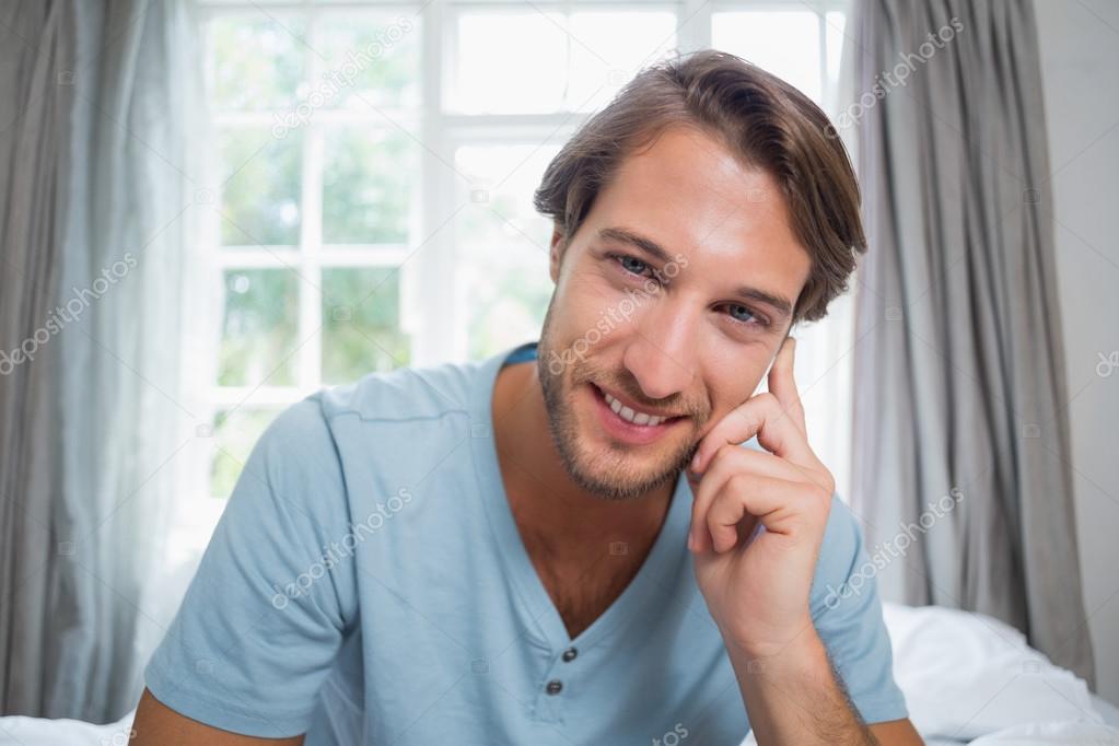 Smiling man sitting on bed — Stock Photo © Wavebreakmedia #48334545