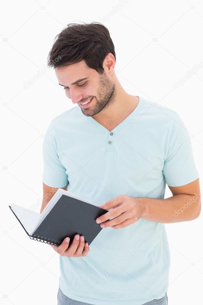 Handsome student reading from notepad Stock Photo by ©Wavebreakmedia ...