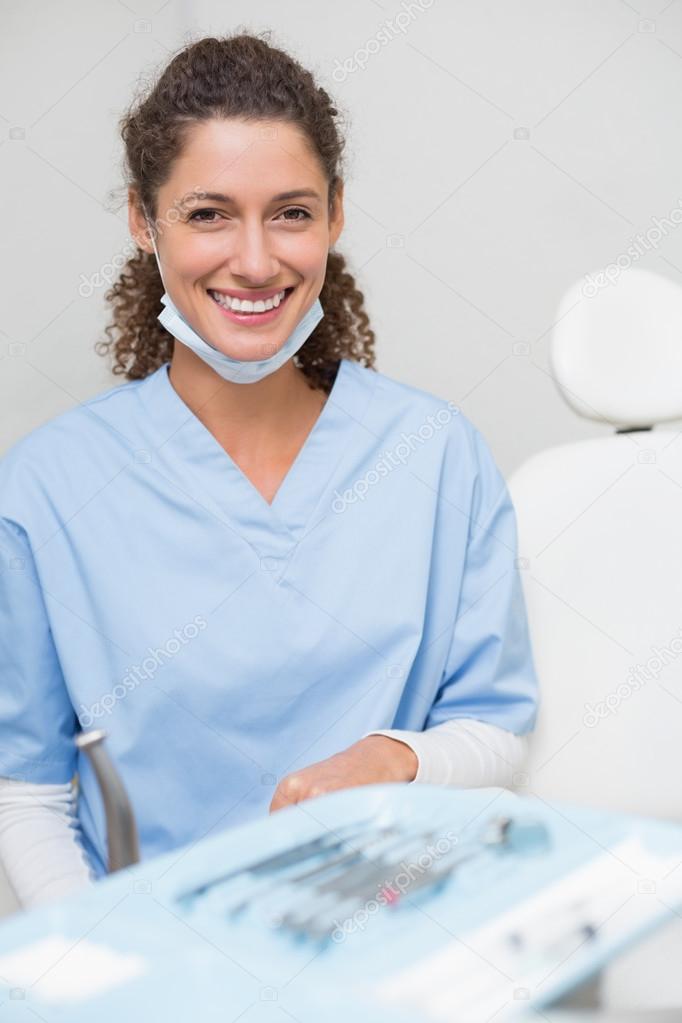 Dentist smiling at camera beside chair — Stock Photo © Wavebreakmedia ...