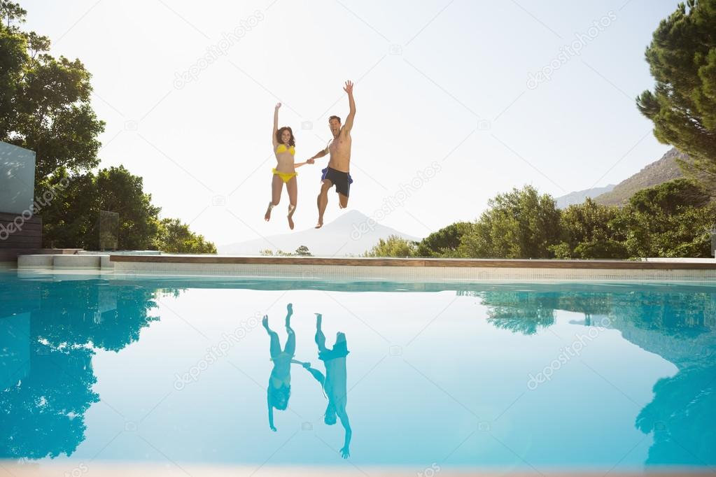 Couple jumping into swimming pool — Stock Photo © Wavebreakmedia #51608279