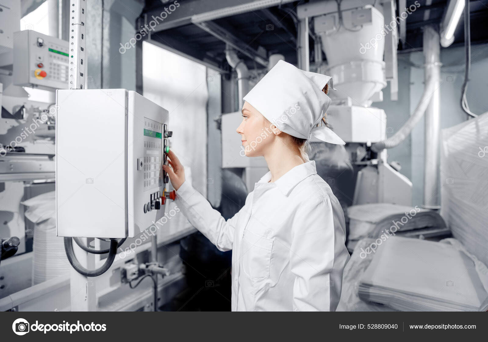 Factory engineer woman operating machine control panel in mill flour ...