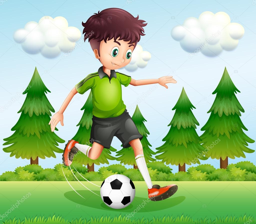 un niño pateando la pelota cerca de los árboles de pino — Archivo ...