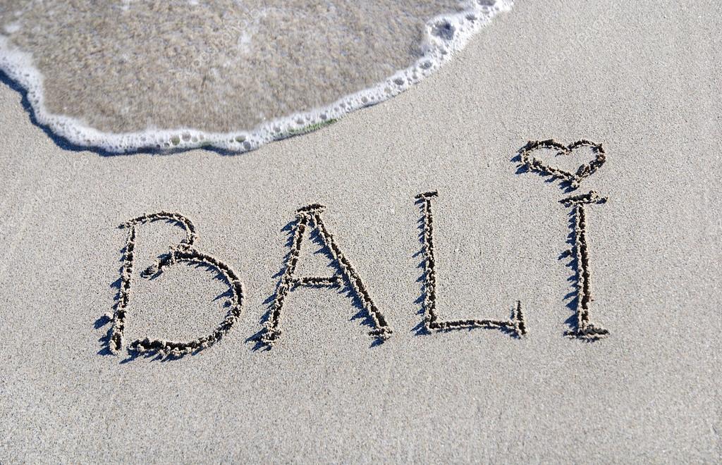 Word Bali outline on the wet sand with the wave brilliance — Stock ...