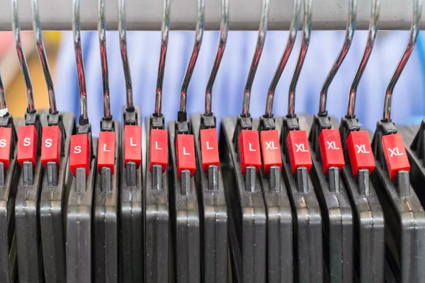 cloth hanger with red sizing label in row - Stock Image - Everypixel