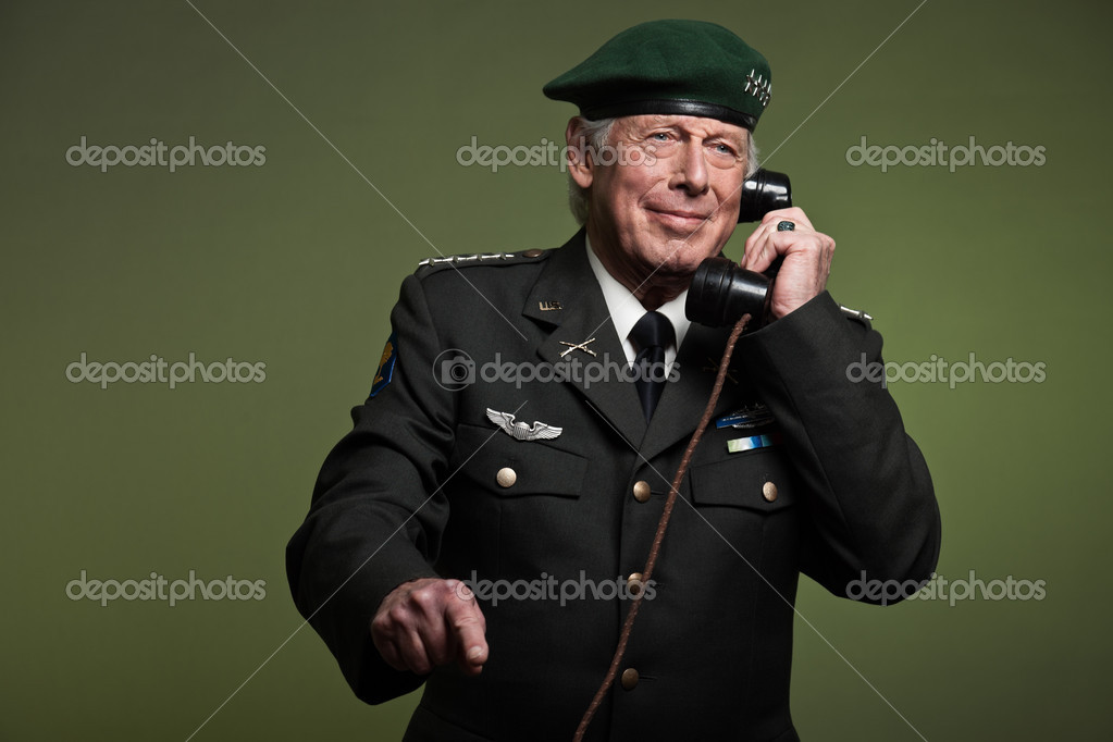 US military general wearing beret. Calling with phone. Studio po ...