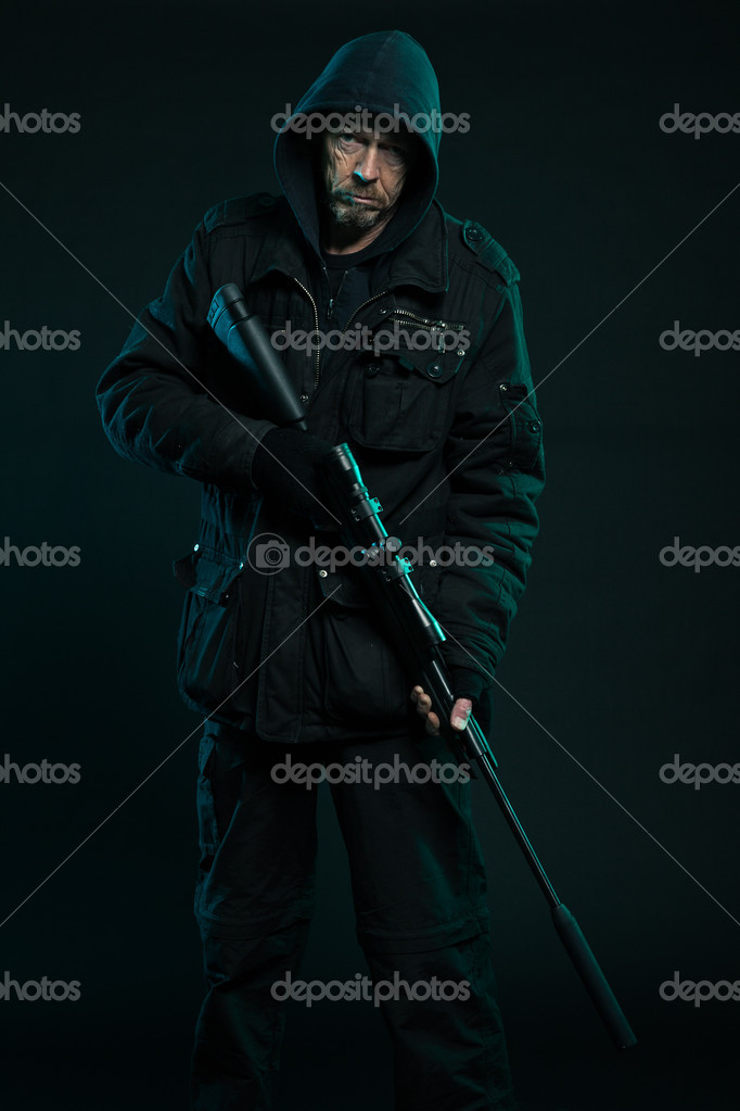 Sniper with beard in black holding gun. Studio shot. — Stock Photo ...