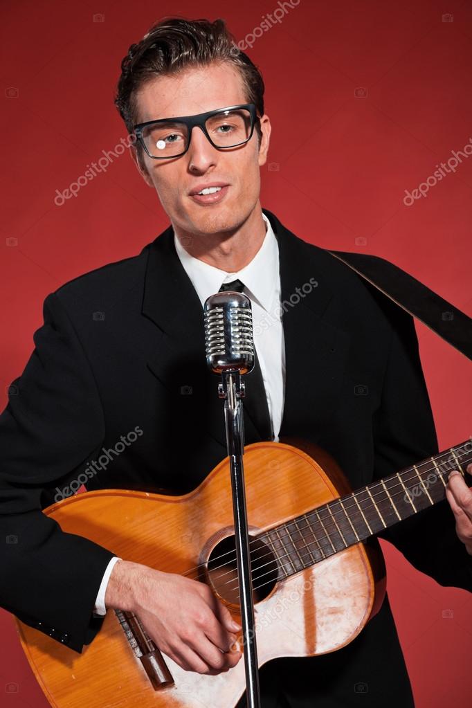Retro fifties singer with glasses playing acoustic guitar. Studi Stock ...