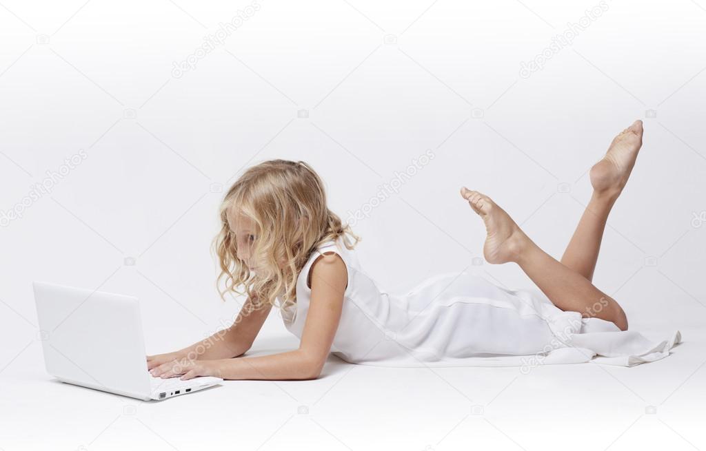 Beautiful young girl in white, operates her computer. White background ...