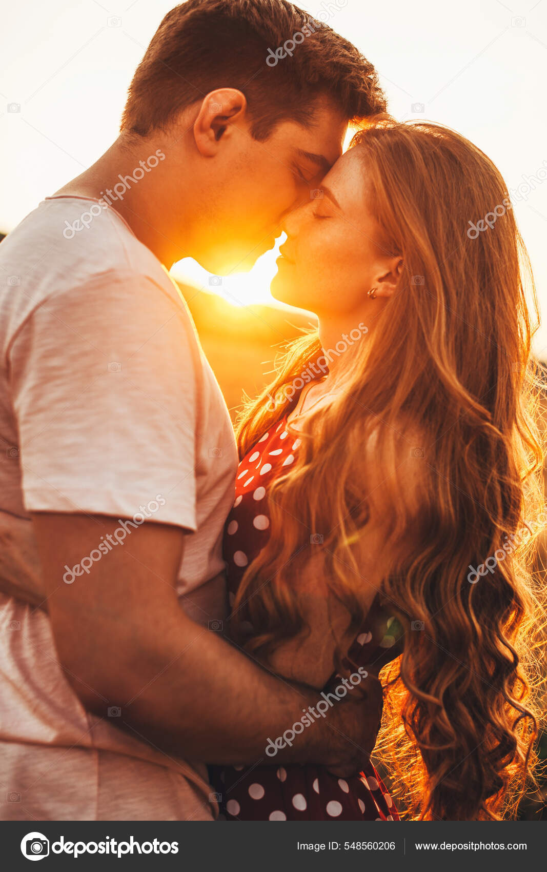 Side view of a couple of newlyweds standing and hugging before a kiss ...