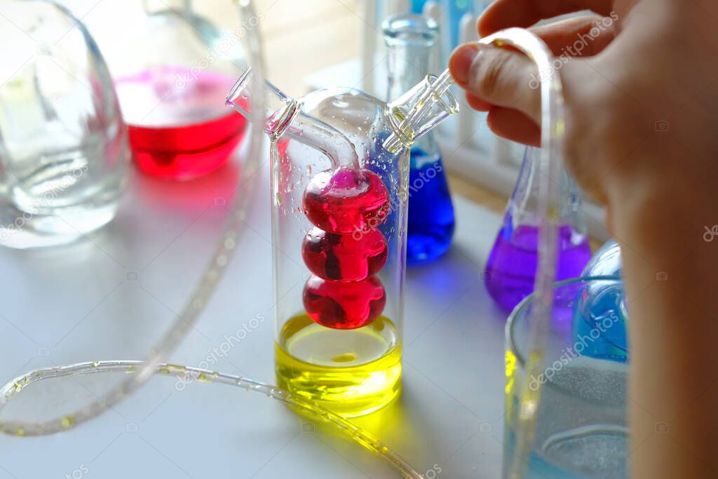 dos niños de 7 a 9 años, niños de escuela primaria, hacen experimentos químicos, vierten ...