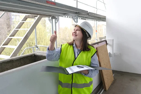 experienced woman architect, constructor engineer in protective white ...