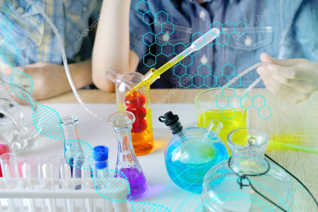 dos niños de 7 a 9 años, niños de escuela primaria, hacen experimentos químicos, vierten ...