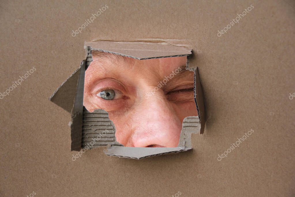 blank cardboard form, craft paper, hole with Human eye, mature man ...