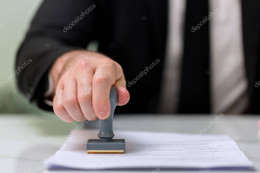 Hombre de negocios sellando con sello aprobado en el documento. Las ...