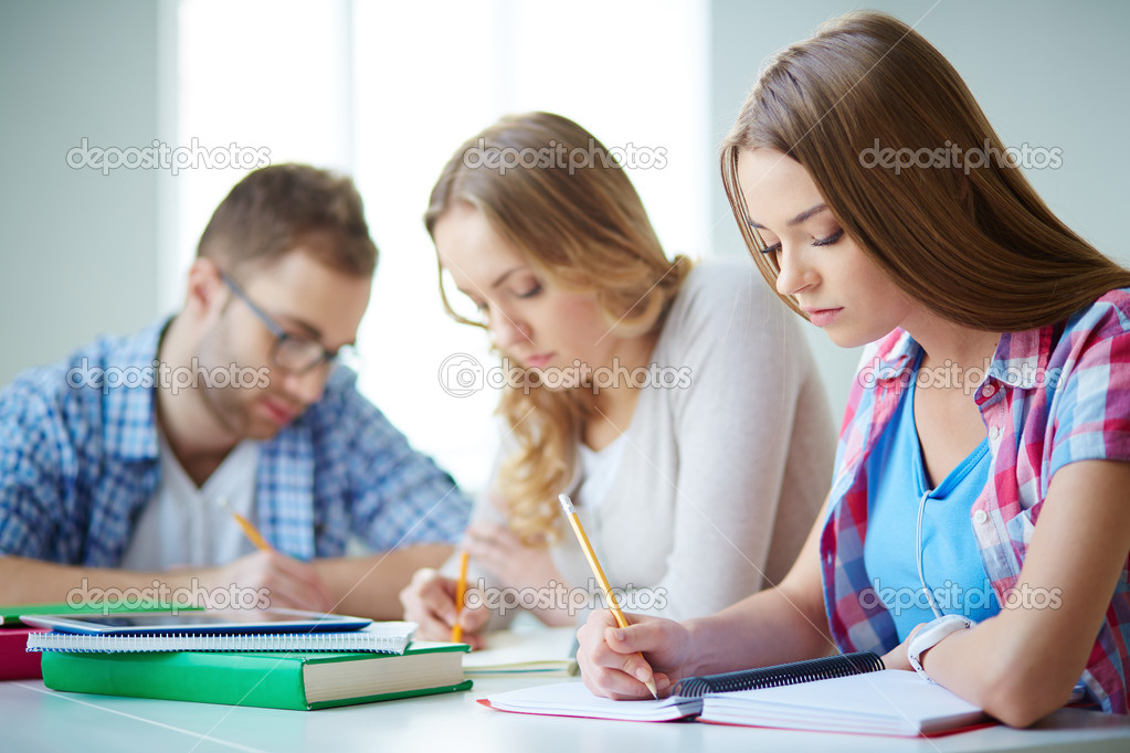 Groupmates carrying out written task Stock Photo by ©pressmaster 49215629