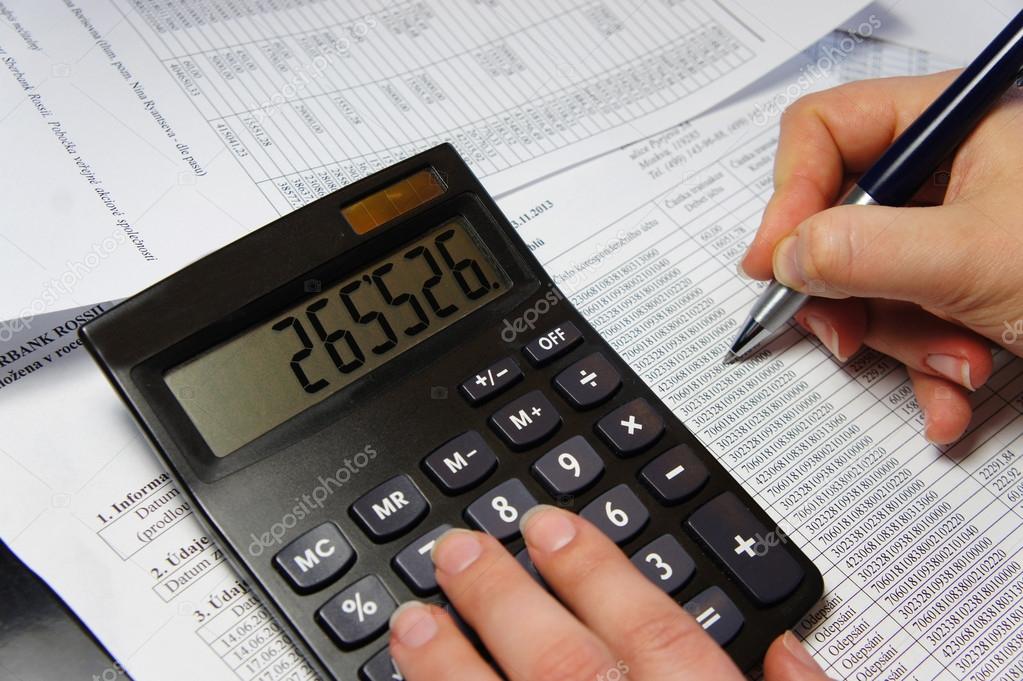 Office table with calculator, pen and accounting document Stock Photo ...
