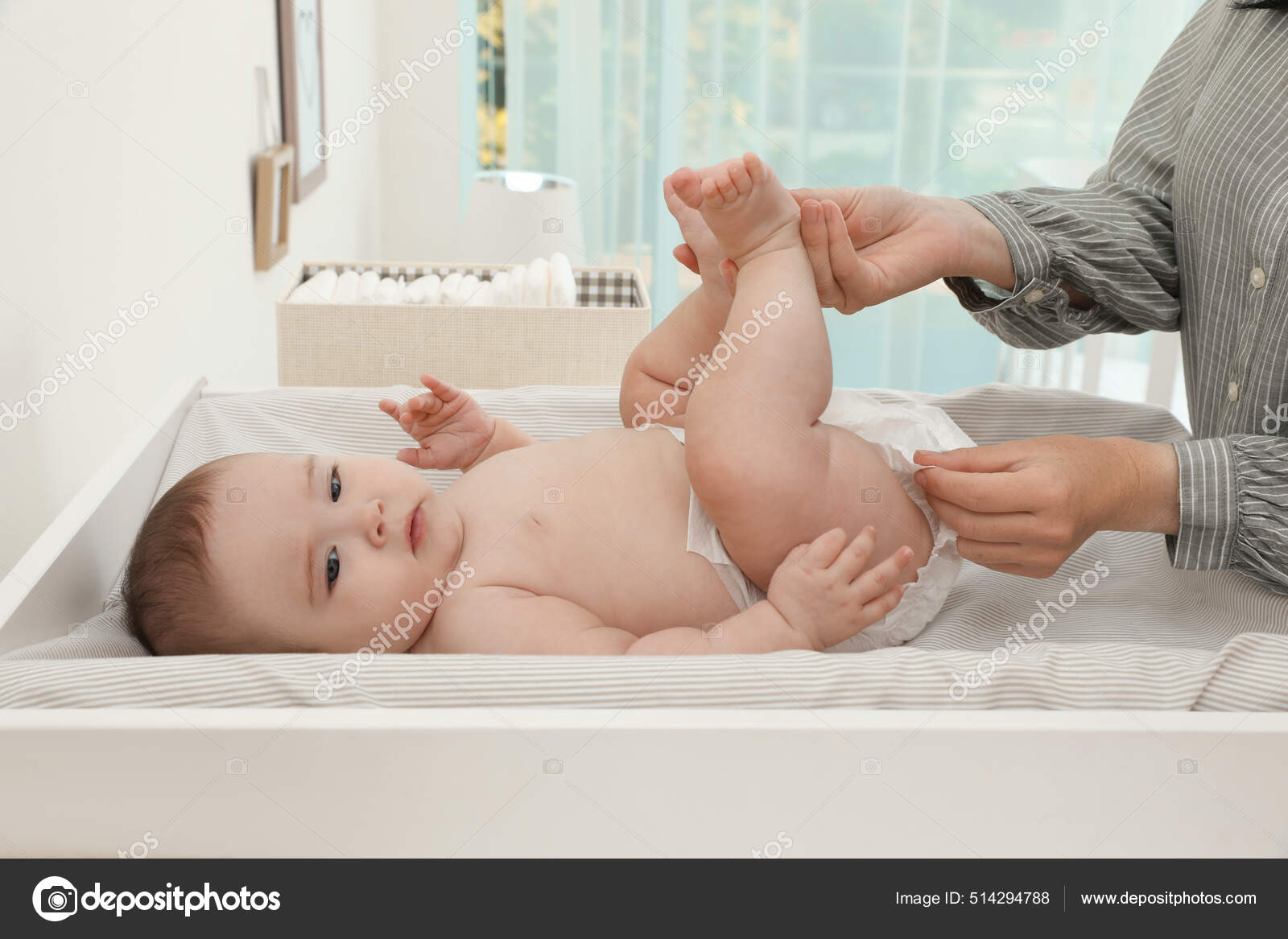 Mother Changing Baby's Diaper Table Home Stock Photo by ©NewAfrica 514294788