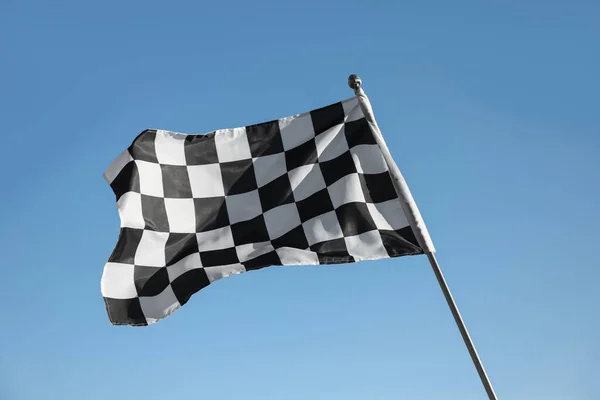Checkered finish flag on light blue background - Stock Image - Everypixel