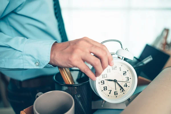 Unemployed pick up alarm clock in to cardboard box and coffee cup ...