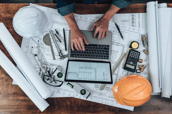 Engineering working with drawings inspection on laptop in the office ...