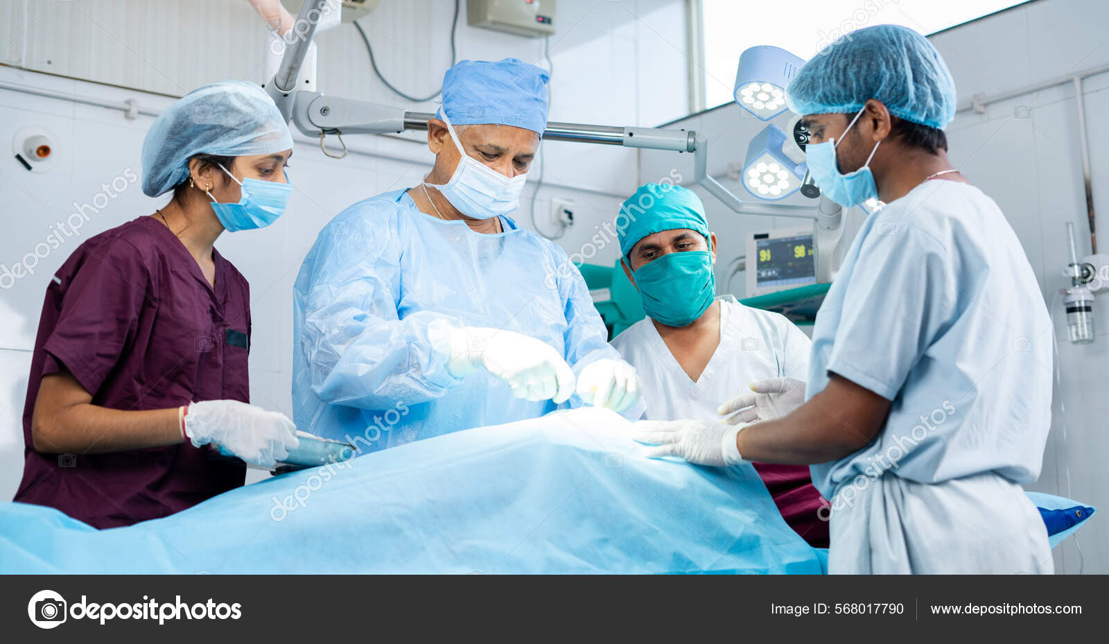 Group of surgeons doing surgery to patient at operation theater ...