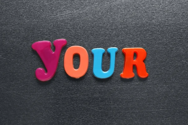 Word your spelled out using colored fridge magnets - Stock Image ...