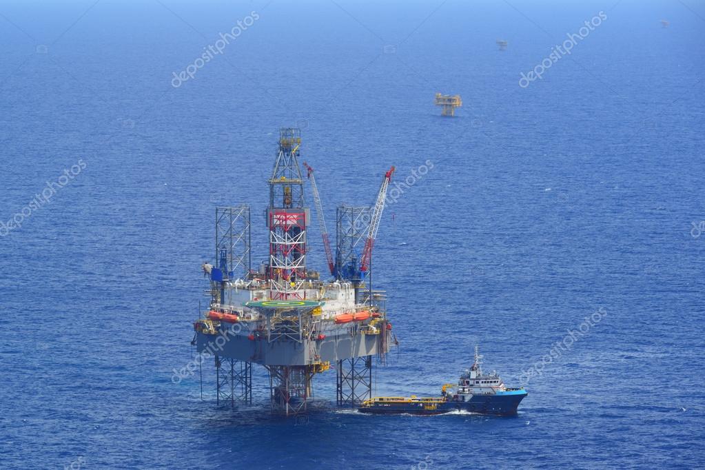 The offshore drilling oil rig and supply boat side view Stock Photo by ...
